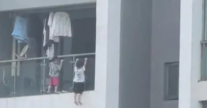 Thót tim cảnh 2 bé trai leo ra ngoài ban công tầng 13, làm động tác 'hít xà đơn'